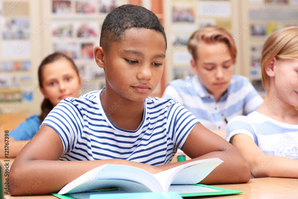 Cute African American boy on lesson in classroom Stock Photo | Adobe Stock