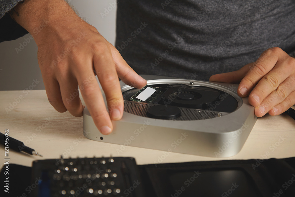 Installing RAM chips into a computer, close up shot of hands and torso ...