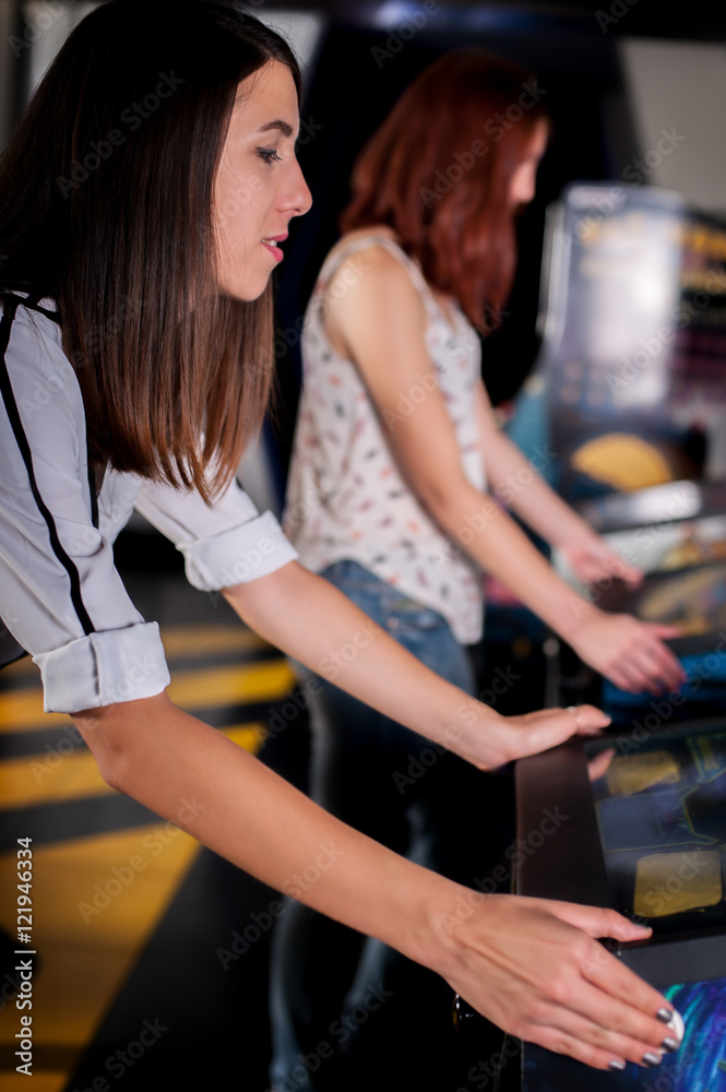 Young woman playing on the pinball machine Stock Photo | Adobe Stock