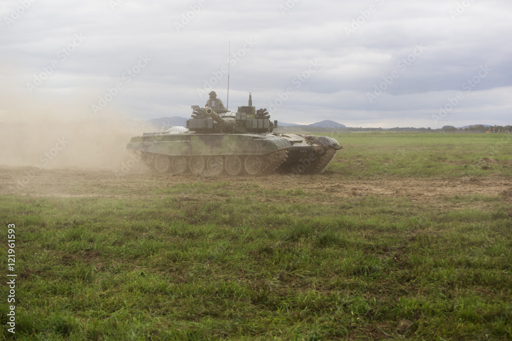 Military vehicle, heavy battle tank, is moving in terrain, cloud of ...