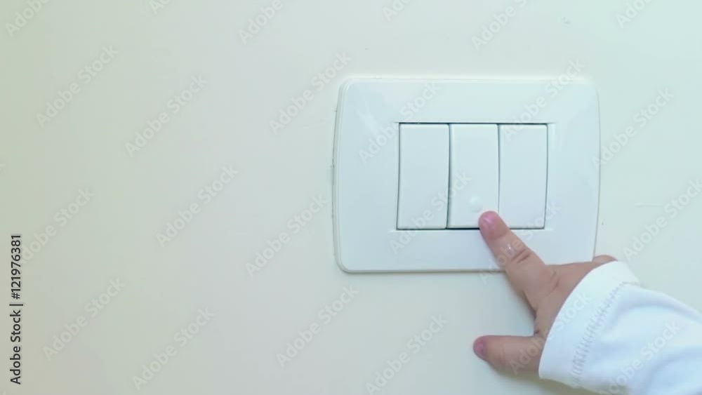 little boy child turning on the white light-switch with his finger of ...