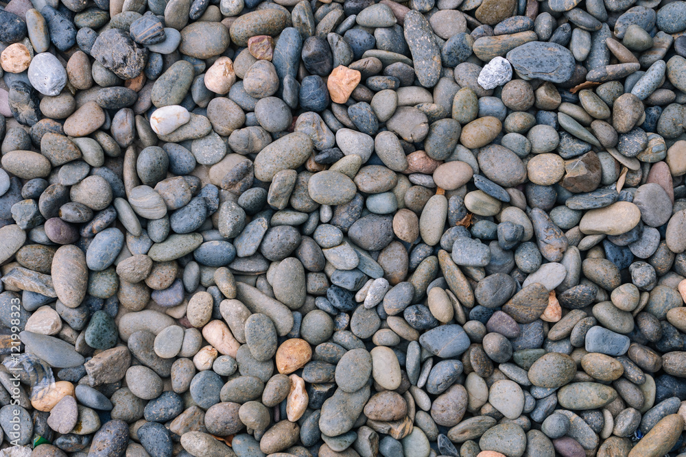 Colorful round rocks floor background with a black and white round rock ...