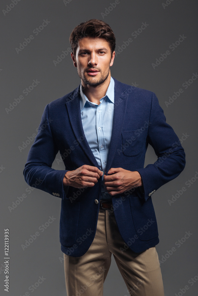 Portrait of a casual handsome man buttoning his jacket Stock Photo ...