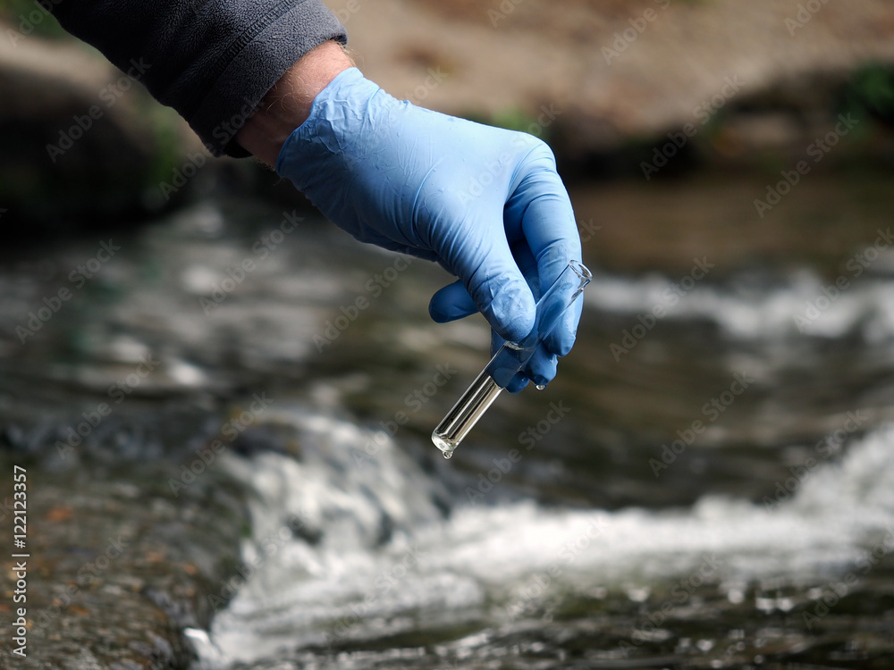 Water sample. Gloved hand into the water collecting tube. Analysis of ...
