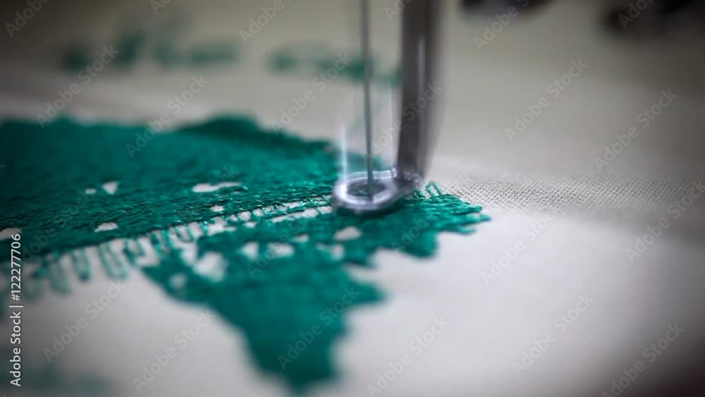 A close up of an industrial sewing machine embroiders fabric. Stock ...