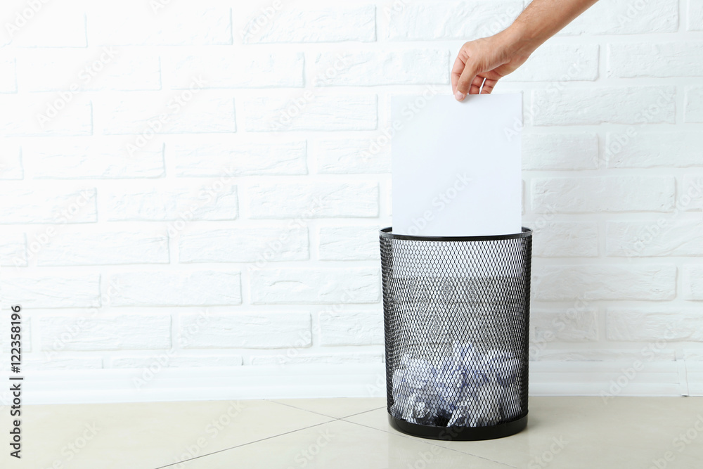 Male hand throwing blank sheet of paper into metal trashcan Stock Photo ...