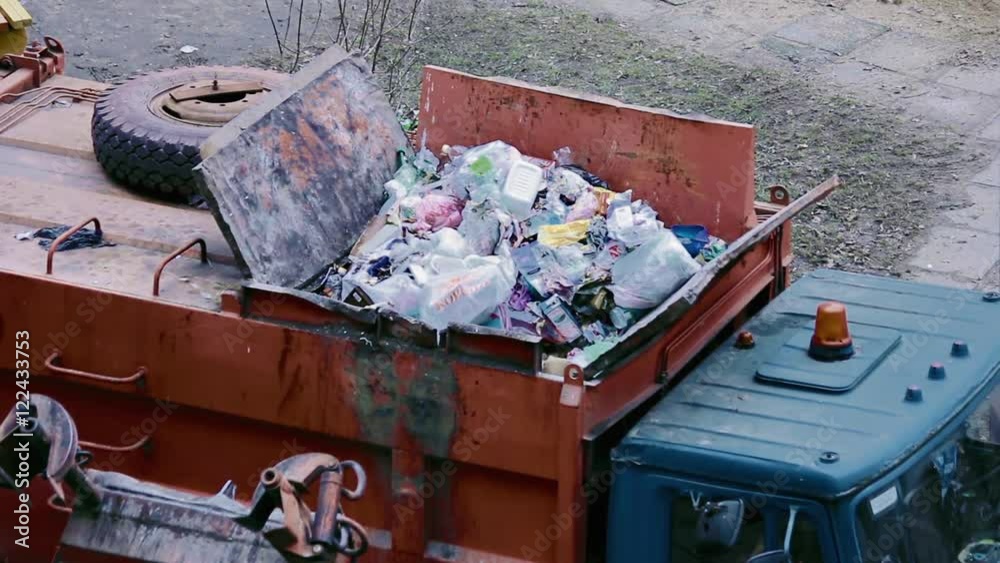 Waste in the garbage truck. Driver gets into the cab, and the truck ...