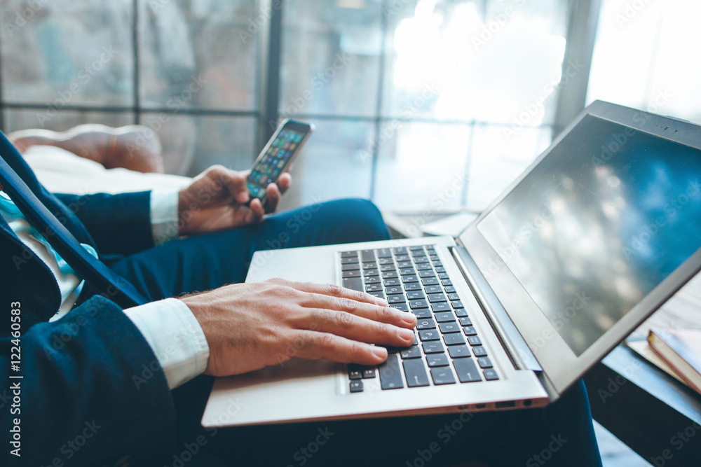 Man sitting with laptop and smartphone. Means of communication. Modern ...