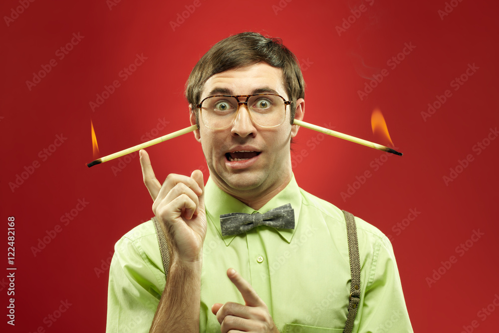 Foto de Portrait of typical nerd with burning sticks in his ears having ...