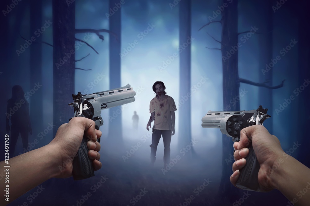 Foto de Man hand holding two gun and ready to shooting walking zombie ...