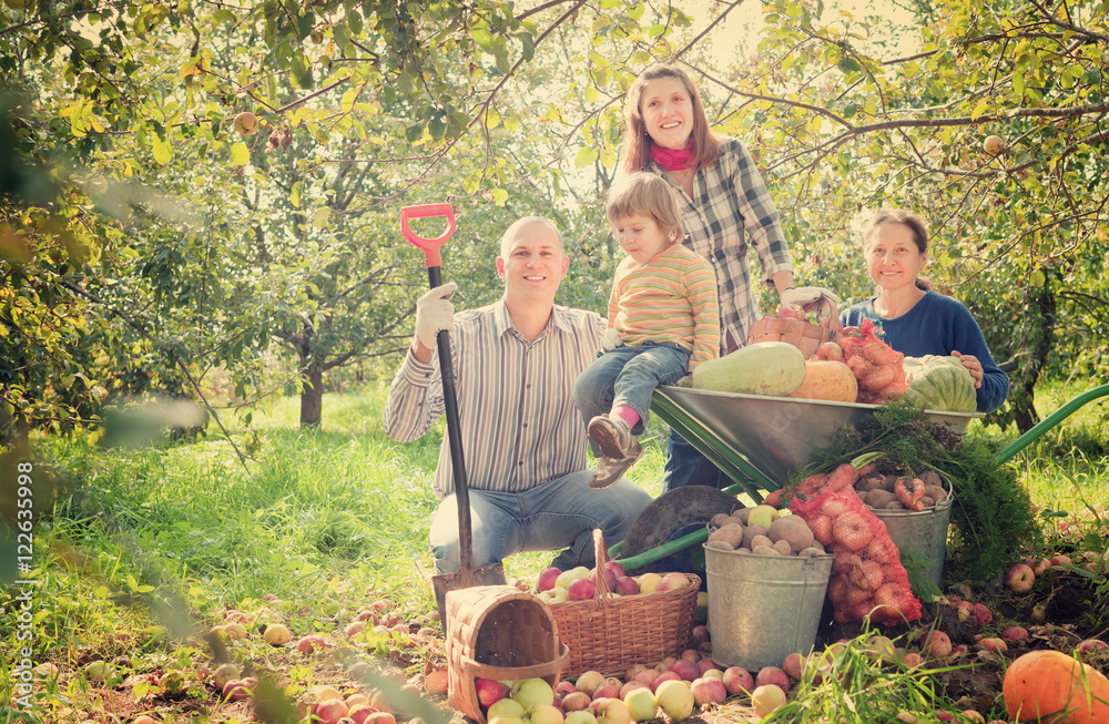 Happy family with harvest in garden Stock Photo | Adobe Stock