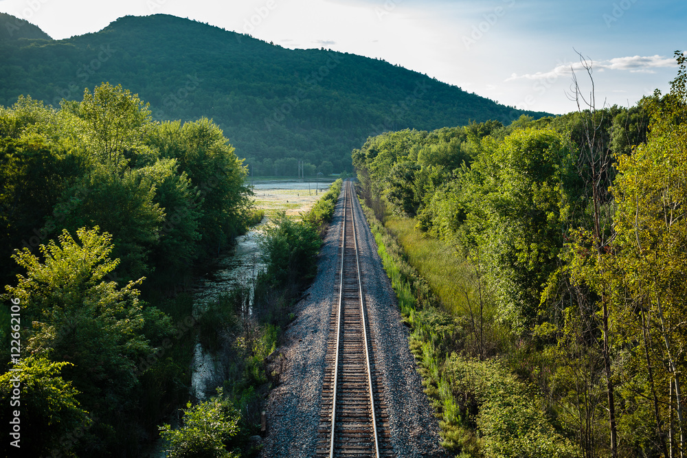 Railway track heading towards green hills Stock Photo | Adobe Stock Railway track heading towards green hills Stock Photo | Adobe Stock