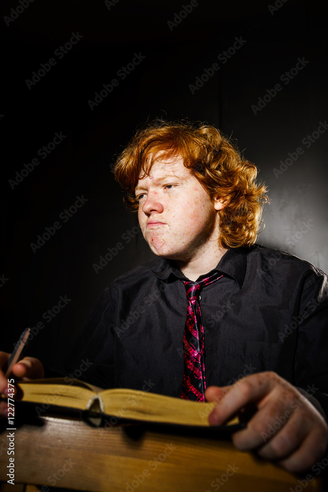 Freckled red-haired teenage boy reading book, education concept Stock ...