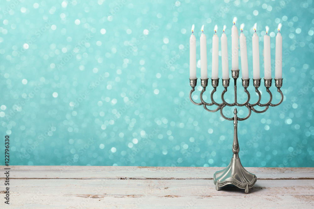 Menorah with candles for Hanukkah celebration over bokeh background ...