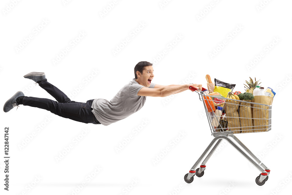 Man being pulled by a shopping cart full of groceries Stock Photo ...