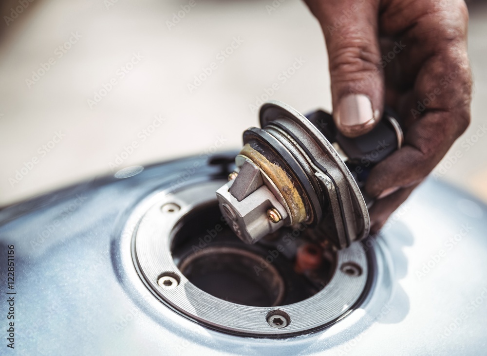 Mechanic opening a fuel tank of motor bike Stock Photo | Adobe Stock