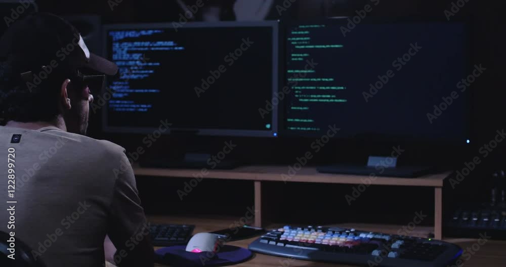 Cyber Terror - Computer Hacker sitting in a dark room in front of ...