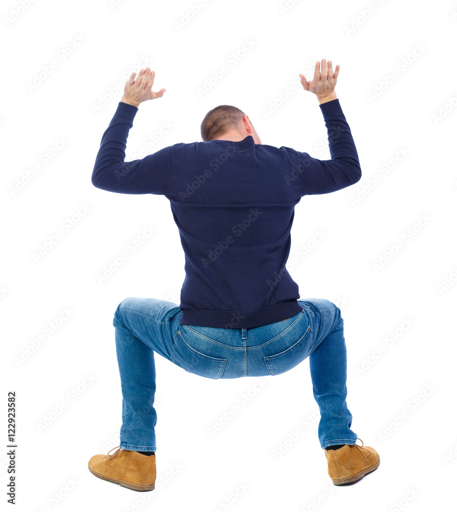 back view. man protects hands from what is falling from above. Man ...