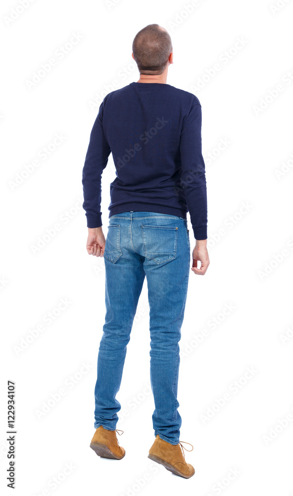 Back view of a curious guy who stood on tiptoes, and peering up ...