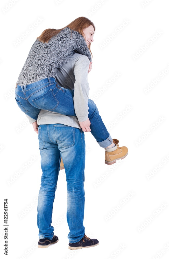 Back view of young embracing couple (man and woman) hug and look into ...