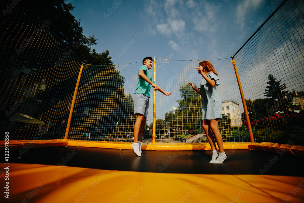 Couple jumping on trampoline in the park Stock Photo | Adobe Stock