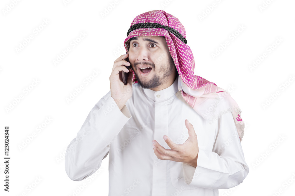 Shocked Arabian man talking on cellphone Stock Photo | Adobe Stock