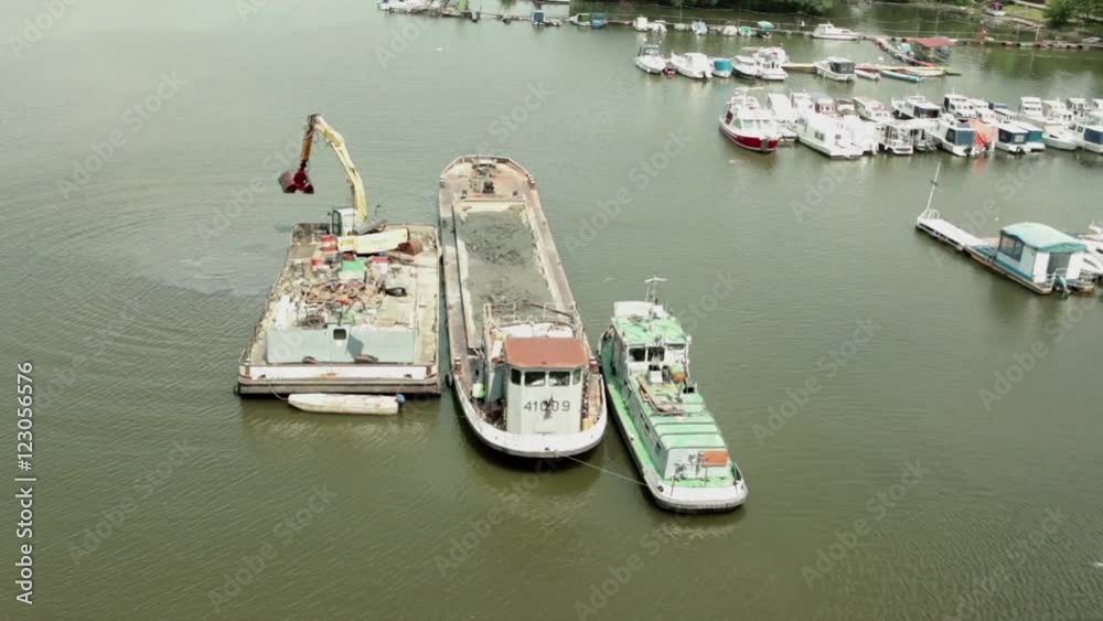 Water transport maintenance - barge with soil excavator removing mud ...