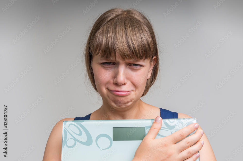 Frustrated overweight woman with scales Stock Photo | Adobe Stock