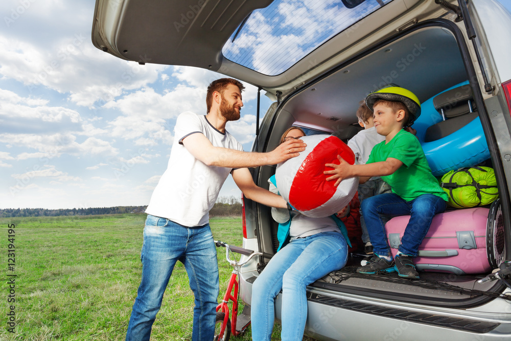 Kid boy helping his father to load their car boot Stock Photo | Adobe Stock