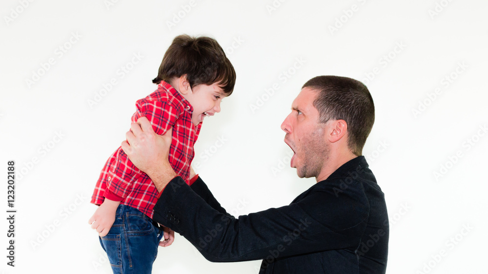 portrait of angry father scolding his son holding his arms, isolated on ...