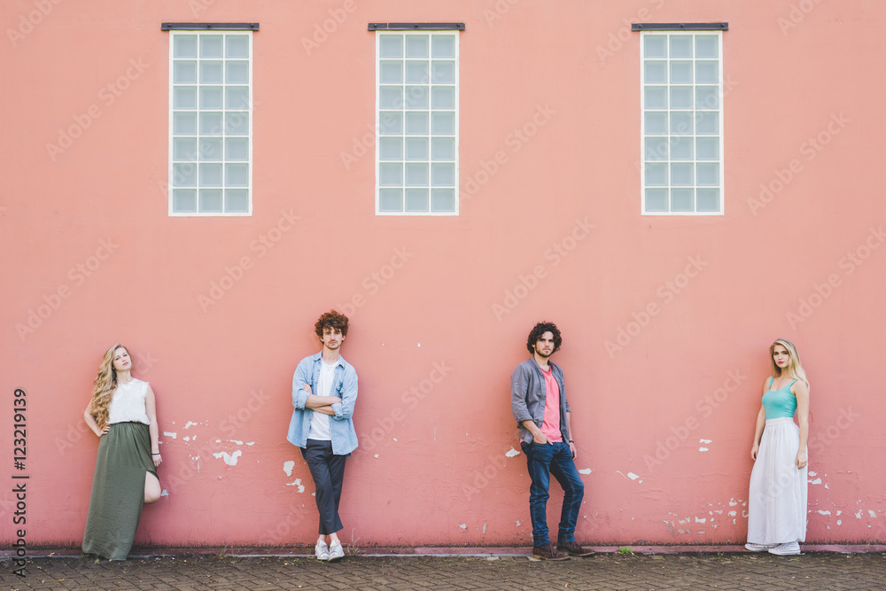 Friends standing against pink wall background Stock Photo | Adobe Stock
