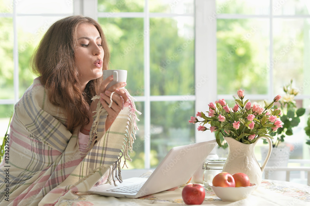 young woman with laptop and tea Stock Photo | Adobe Stock