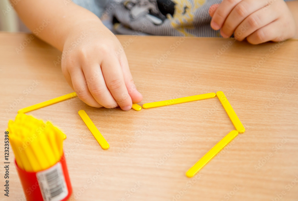 Foto Stock the child puts sticks | Adobe Stock