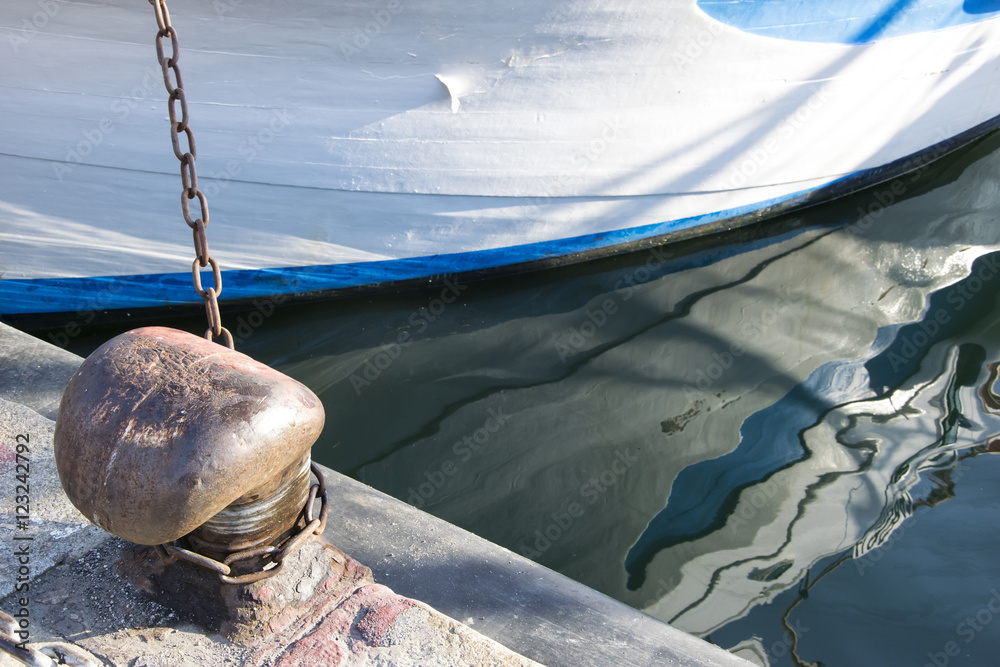 Chain tied on a bollard. Mooring rope wrapped around the cleat on sea ...