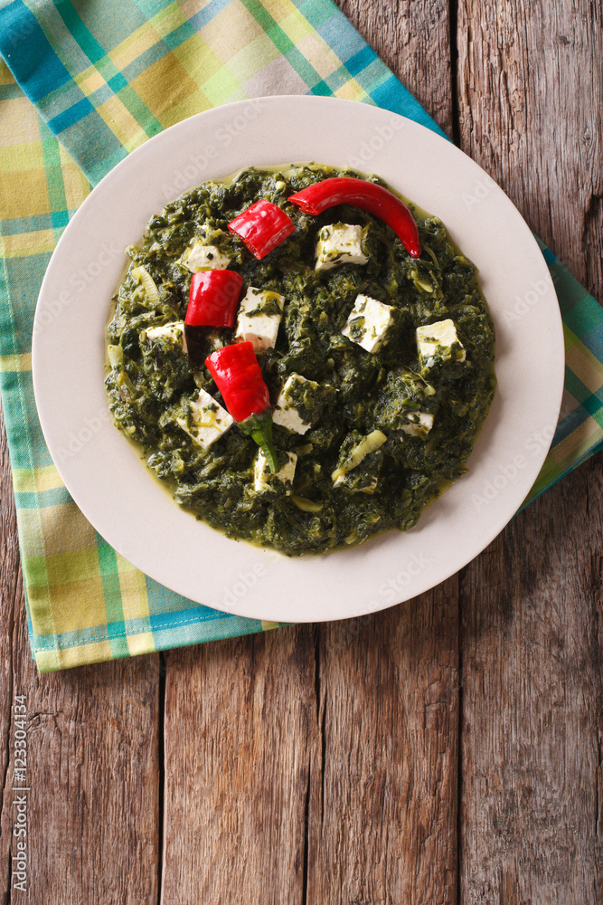 Indian Palak paneer in spicy spinach with cheese close-up. Vertical top ...