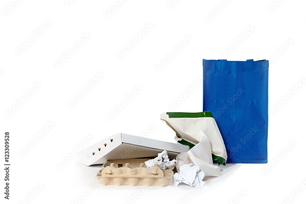Pile of paper waste is lying on the white background. The empty blue ...