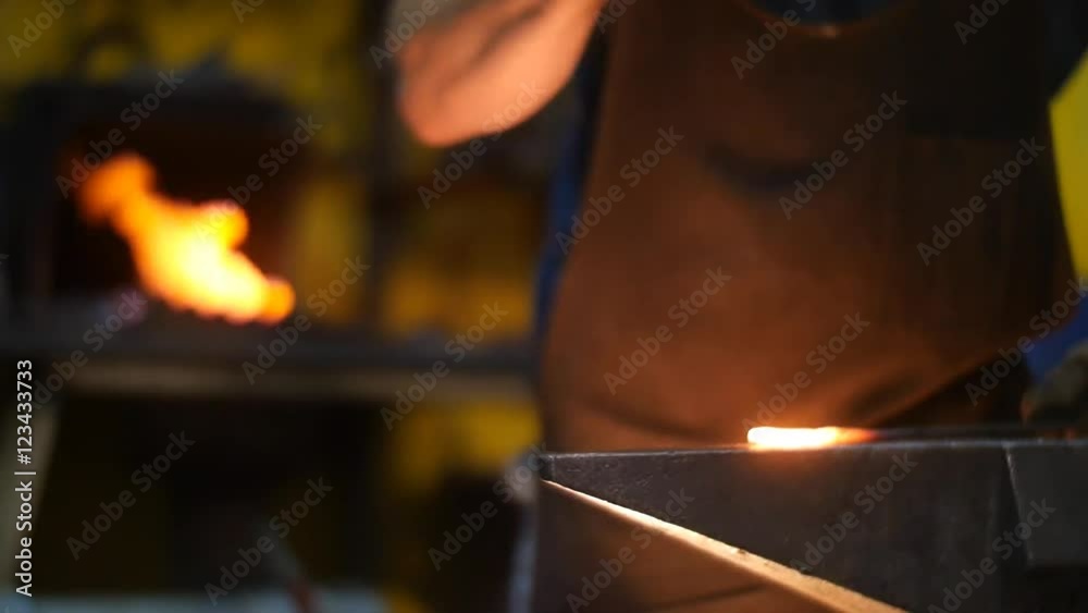 Blacksmith hit with Hammer Hot Metal with Sparks in a Workshop Behind ...