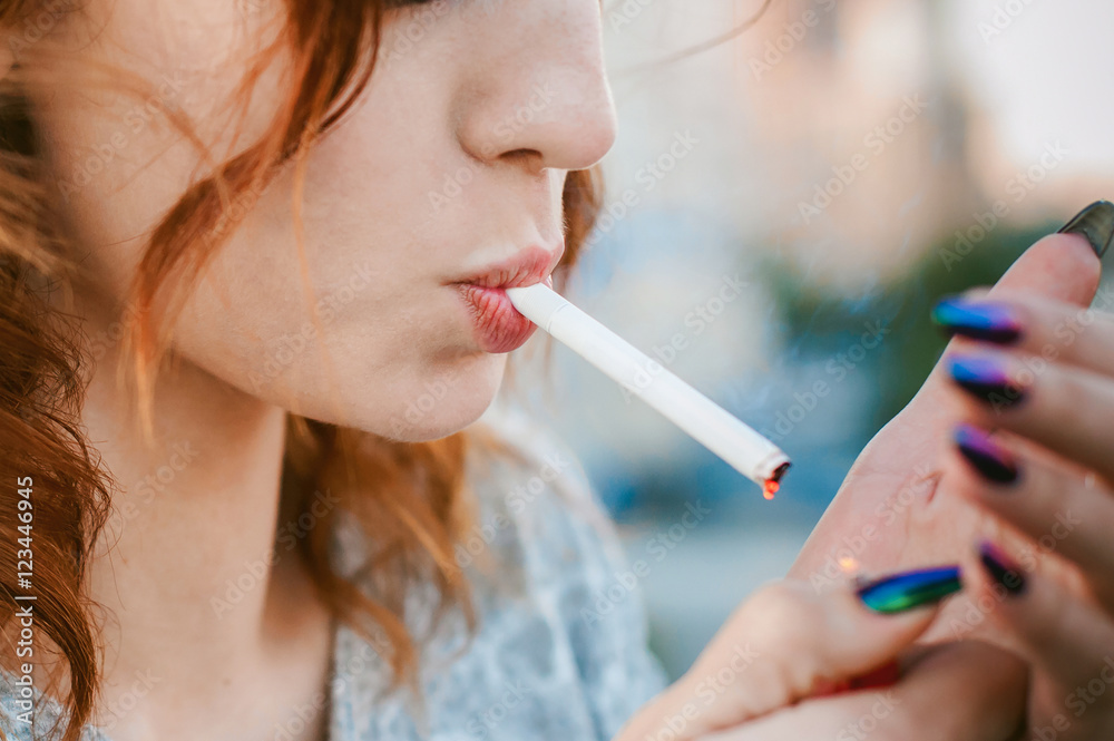 girl with a cigarette. young beautiful girl smokes a cigarette on the ...