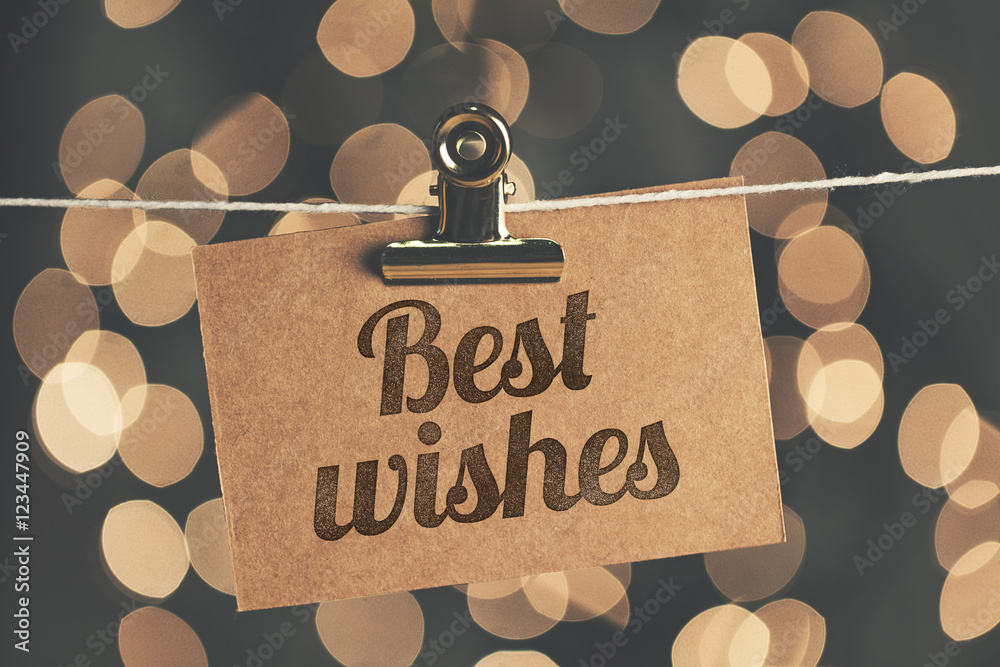 Best wishes sign pegged to a string with blurred bokeh lights in the ...