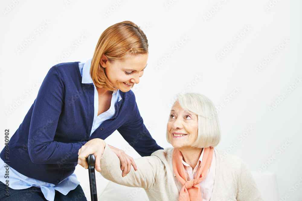 Caregiver helping senior woman getting up Stock Photo | Adobe Stock