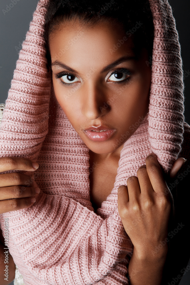 Portrait Of Beautiful Dark Skinned Girl With A Knitted Scarf On A Grey