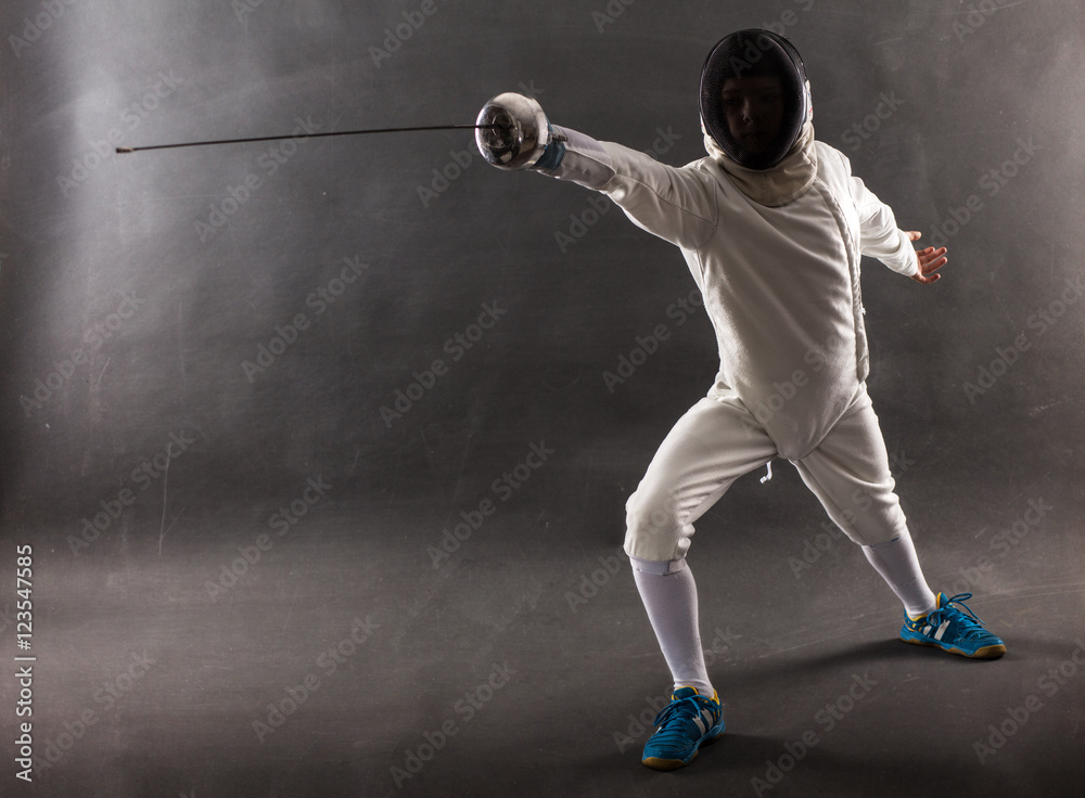Boy wearing white fencing costume and black fencing mask standing with ...