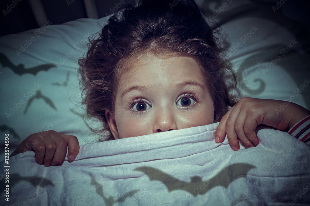 cute little girl with scary eyes under the blanket in her bed Stock ...