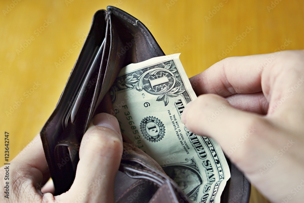 Male hands opening an almost empty leather wallet with only one ...