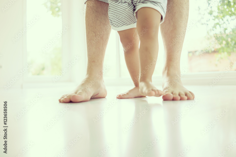 Parenting feet with baby walking first steps Stock Photo | Adobe Stock