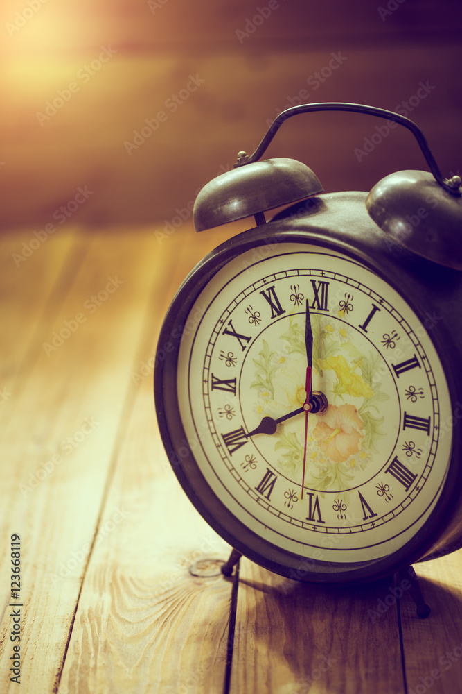 Retro watch with antique number is showing 8 o'clock on wooden ...