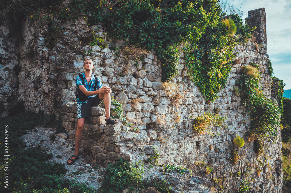 Handsome man in Stari Bar old fortress, Montenegro. Tanned male walking ...