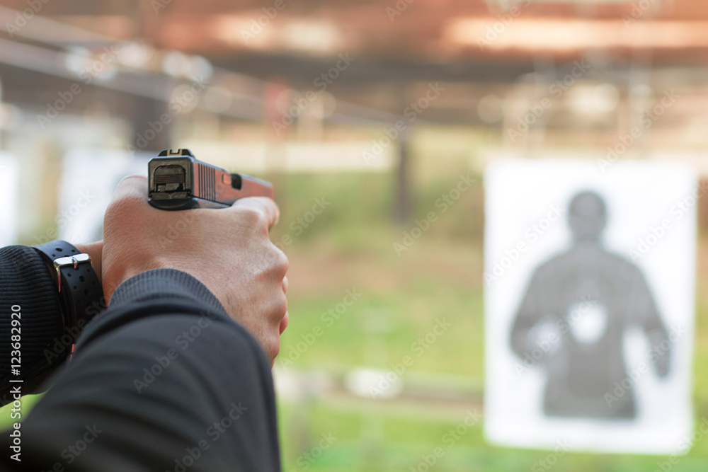 Shooting with a pistol. Man aiming pistol in shooting range. Stock ...