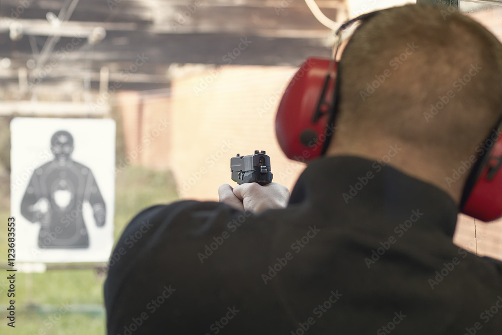 Shooting with a pistol. Man aiming pistol in shooting range. Stock ...