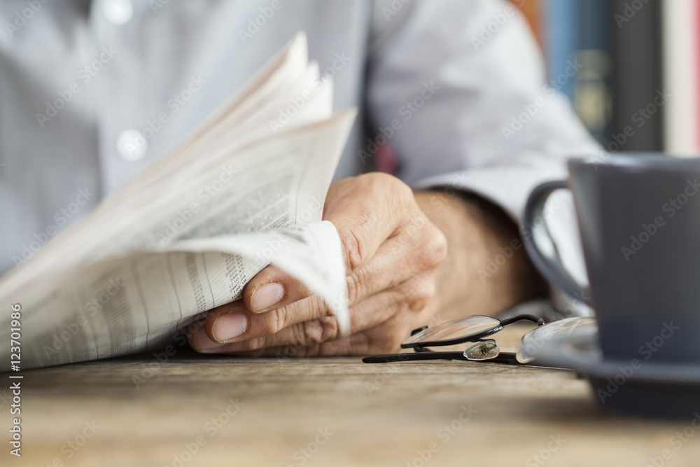 Man newspaper reading on table Stock Photo | Adobe Stock